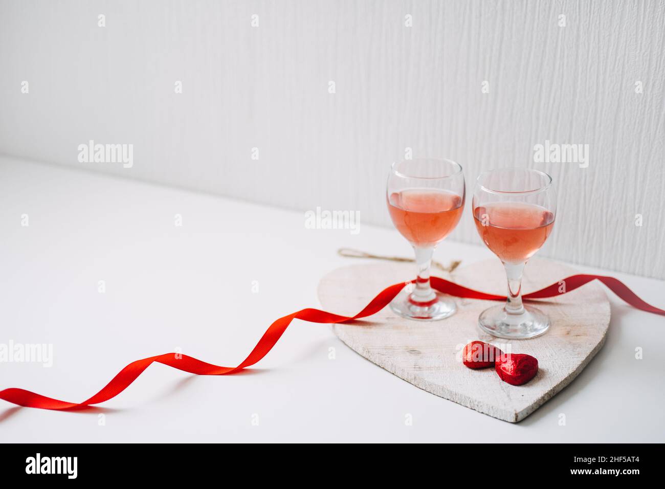 Valentines Day Festive table setting with two glasses of rose wine, red ...