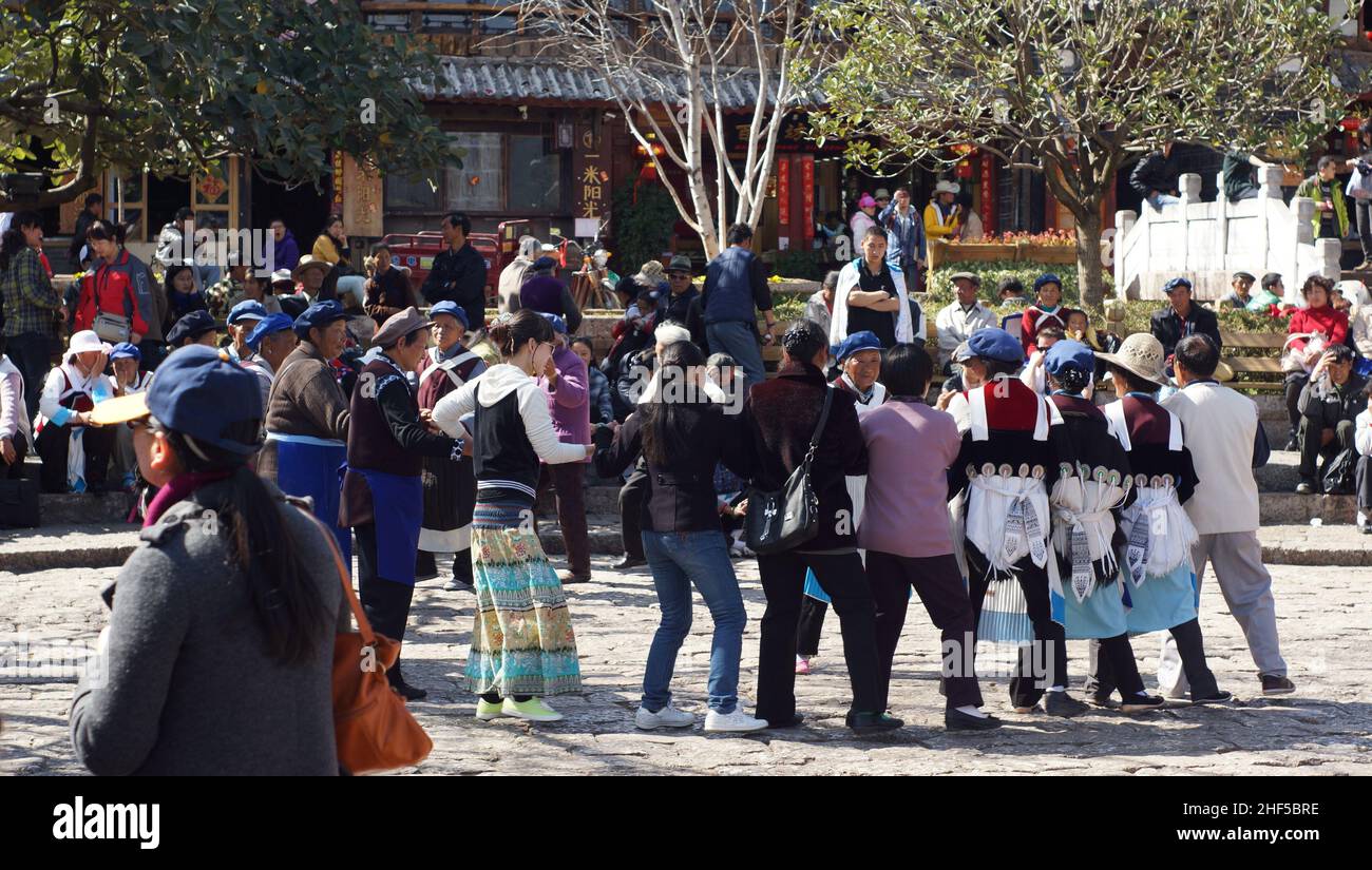 LIJIANG, CHINA - FEBRUARY 20: Nakhi women dance around the square in ...