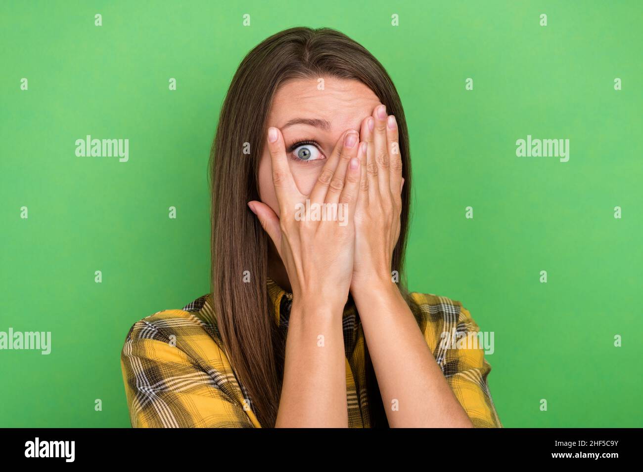Portrait of puzzled terrified lady arms palms covering face eye peeking ...