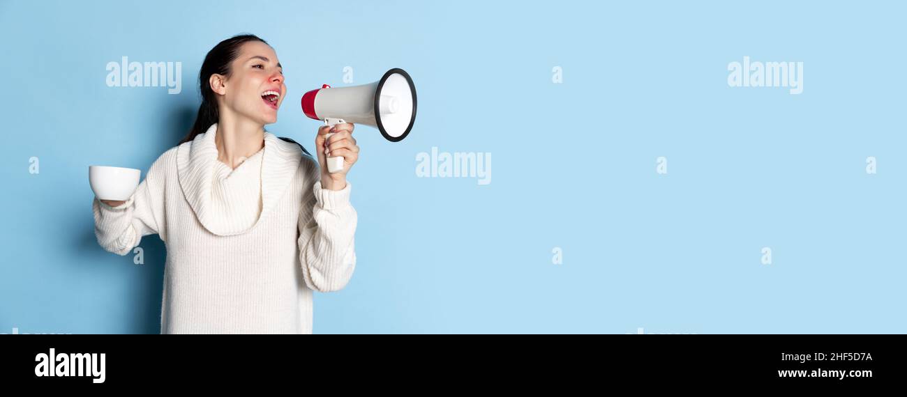 Emotional ill, sick young girl with red nose shouting at megaphone ...