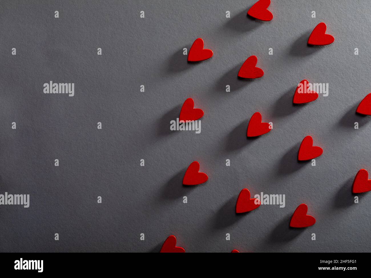 Overhead view of red heart shaped decorations arranged over gray ...