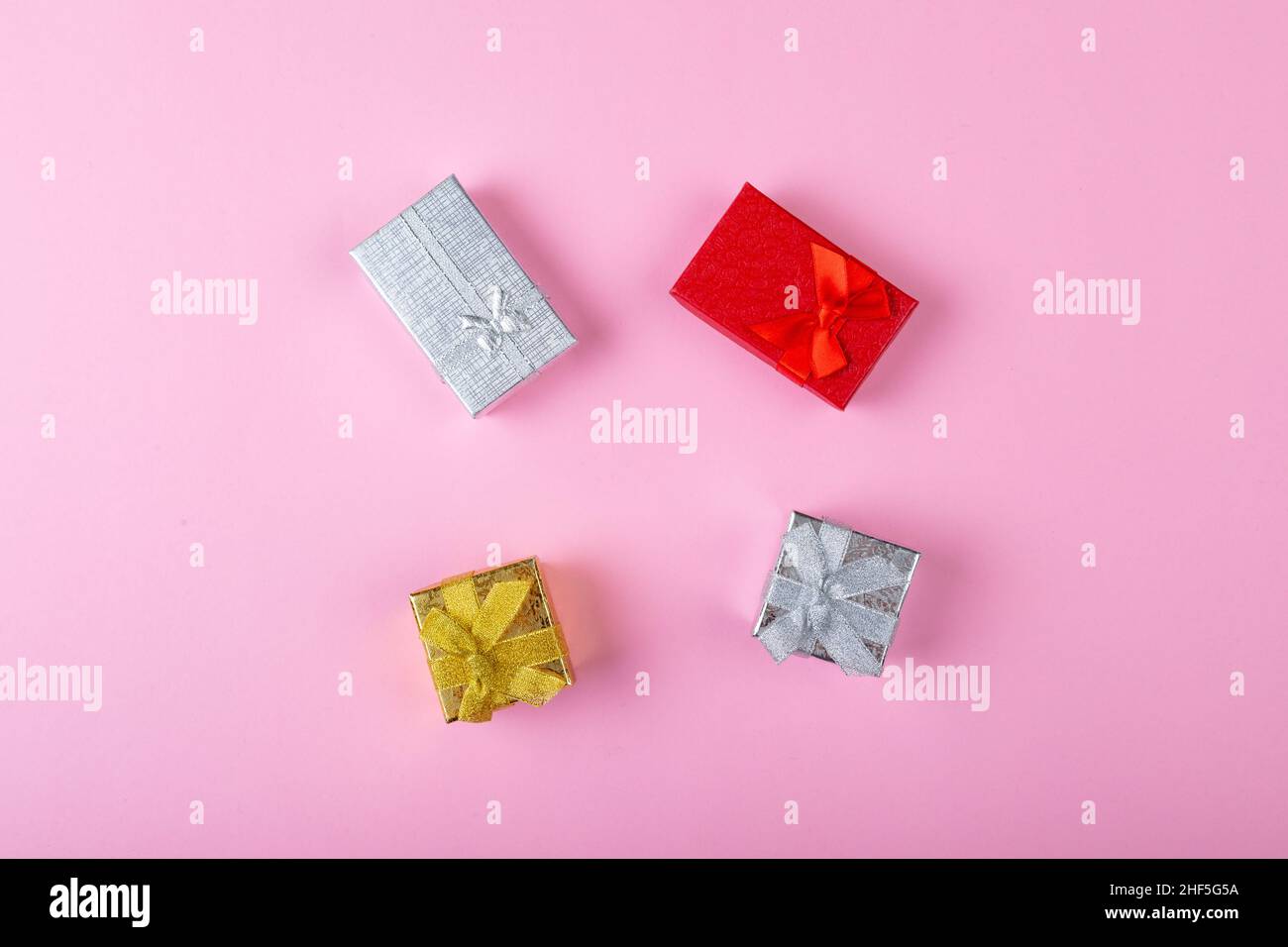 Overhead view of multi colored valentine present boxes on pink ...