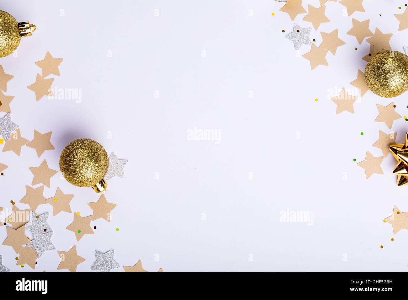 Golden baubles with star shape decorations along copy space on white ...