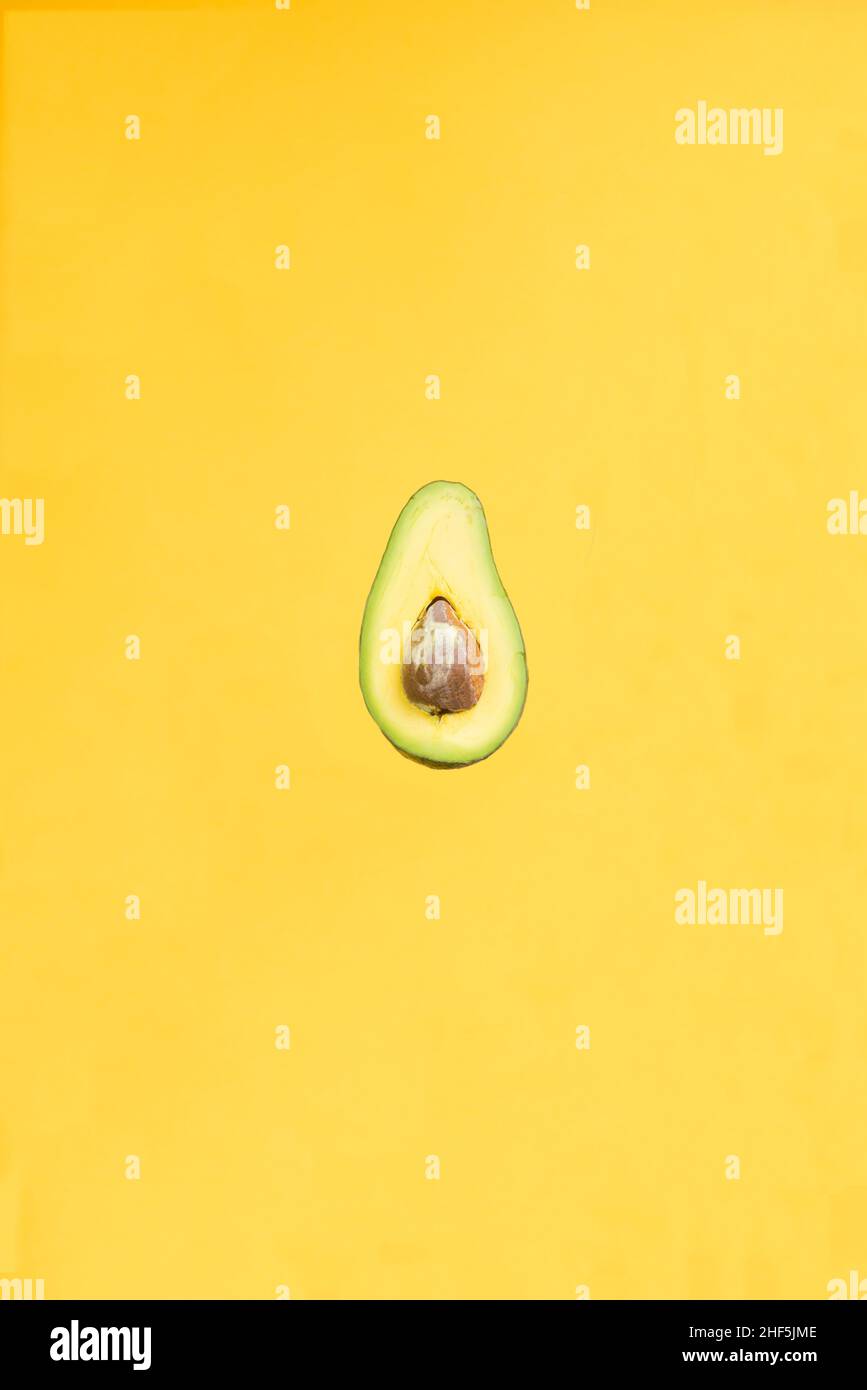 avocado fruit isolated in yellow background Stock Photo - Alamy