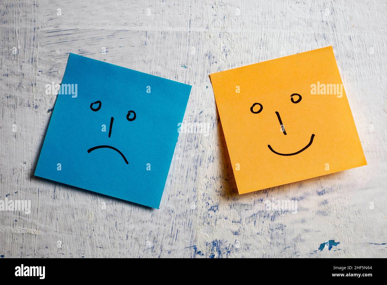 Happy and sad faces hand drawn on sticky notes on painted wall Stock ...