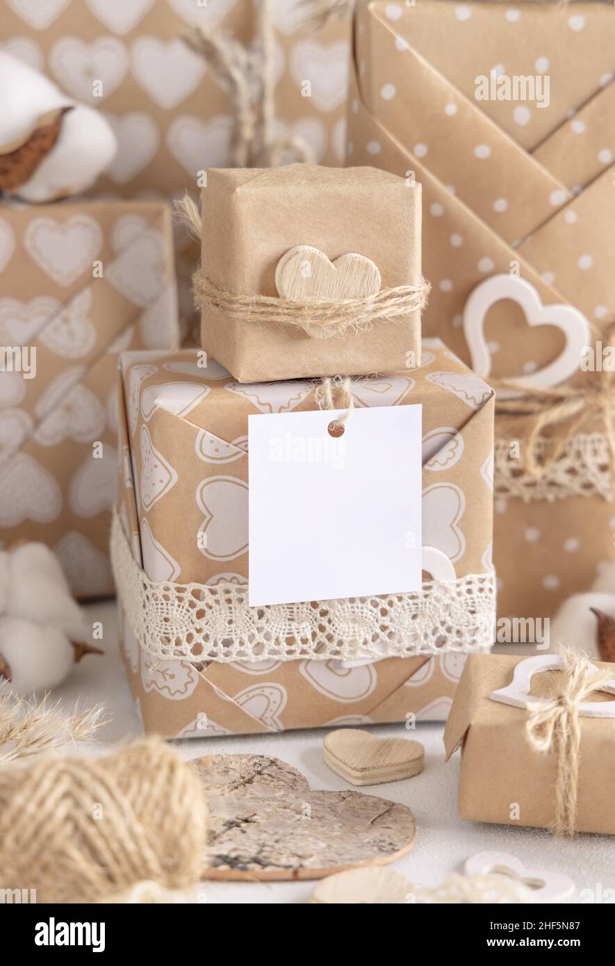 Valentines kraft paper wrapped presents with square gift tag and hearts ...