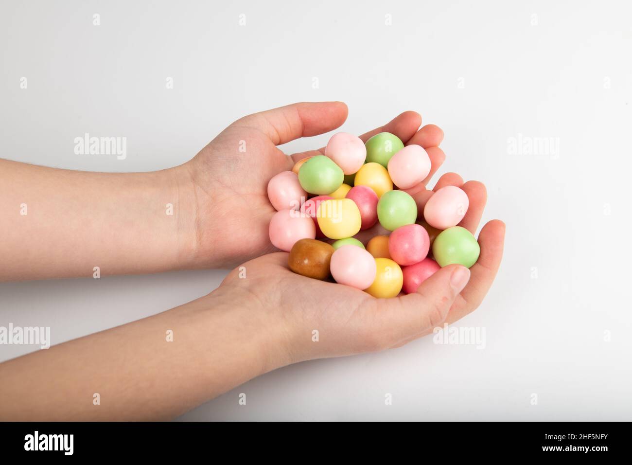 Child holding candy in his hands on white background Stock Photo - Alamy