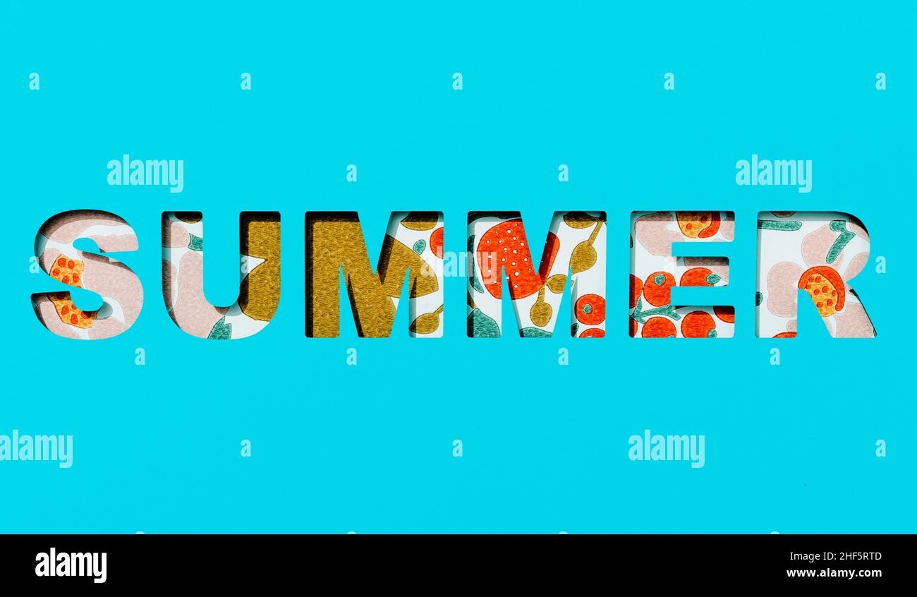 the word summer cut out on a blue paper, and a floral background seen ...