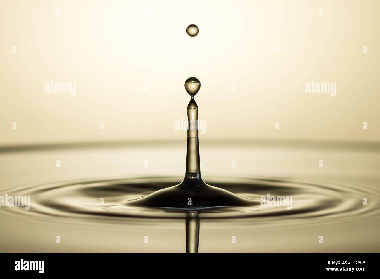 Macro photo of a gold drop falling into it Stock Photo - Alamy