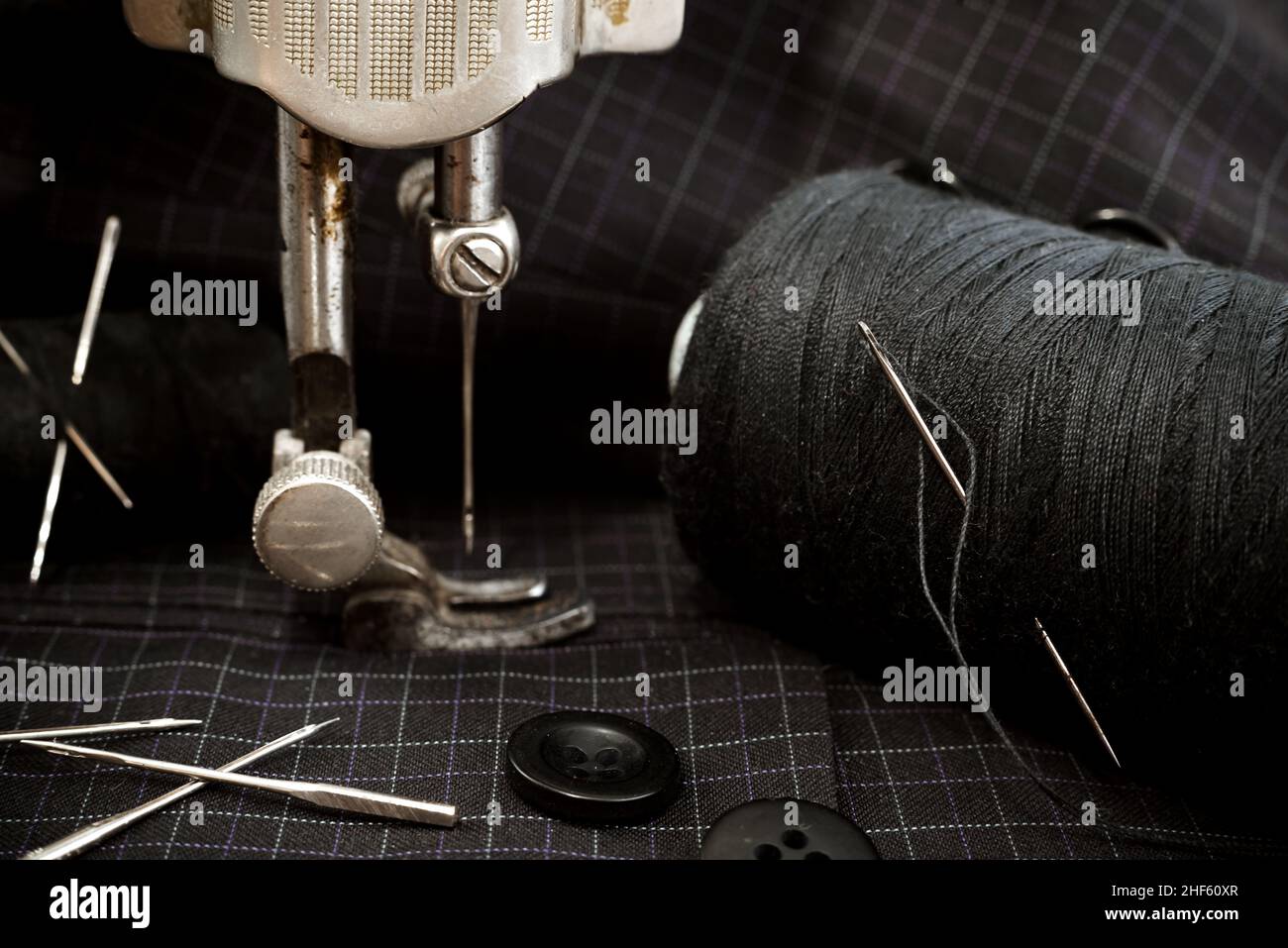 Old retro sewing machine, needle with thread, scissors and thimble ...