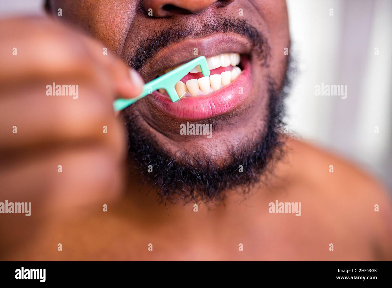 african american man cleaning his teeth with floss Stock Photo - Alamy