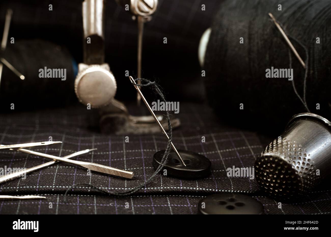 Old retro sewing machine, needle with thread, scissors and thimble ...