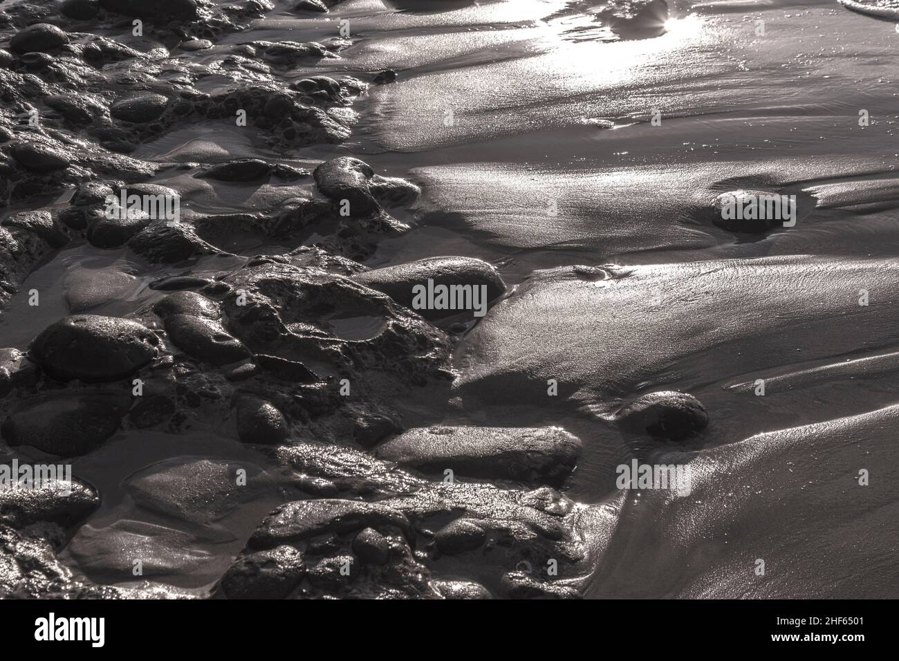 pebble stone beach in morning light with harmonic reflections Stock ...