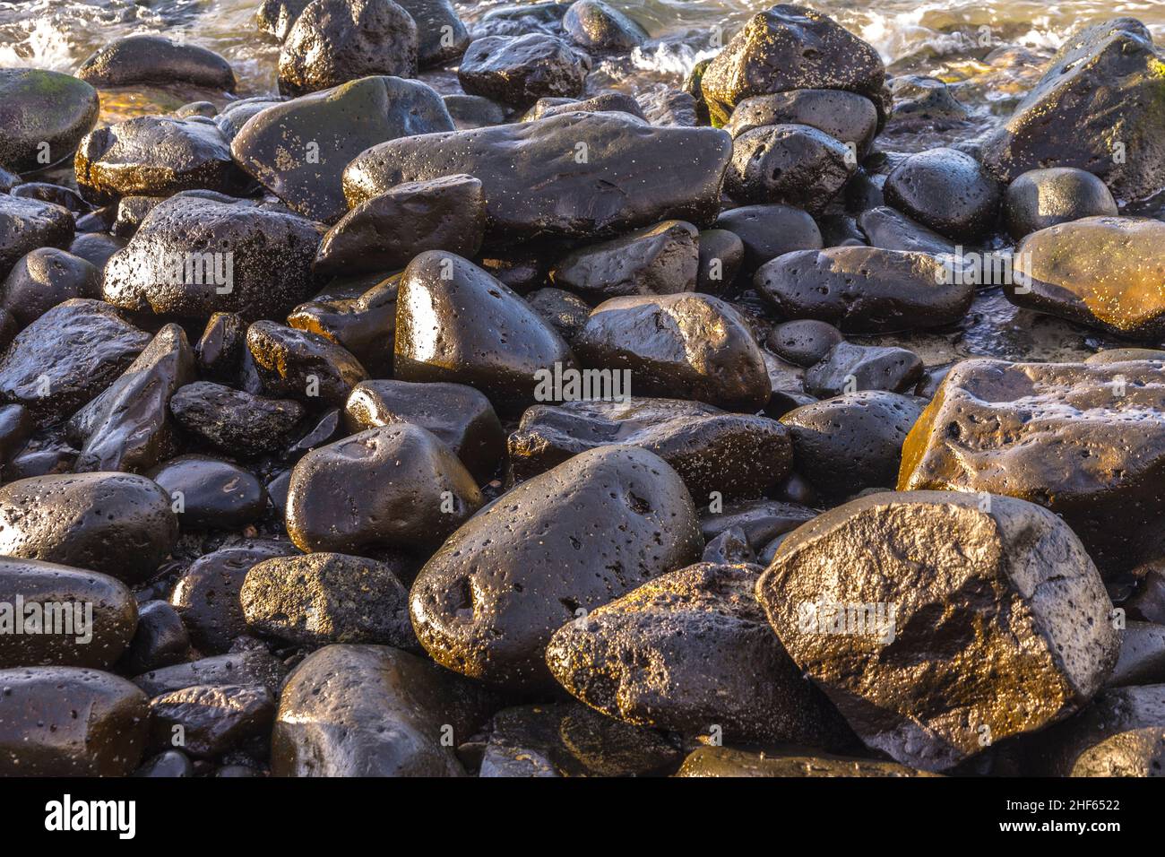 pebble stone beach in morning light with harmonic reflections Stock ...