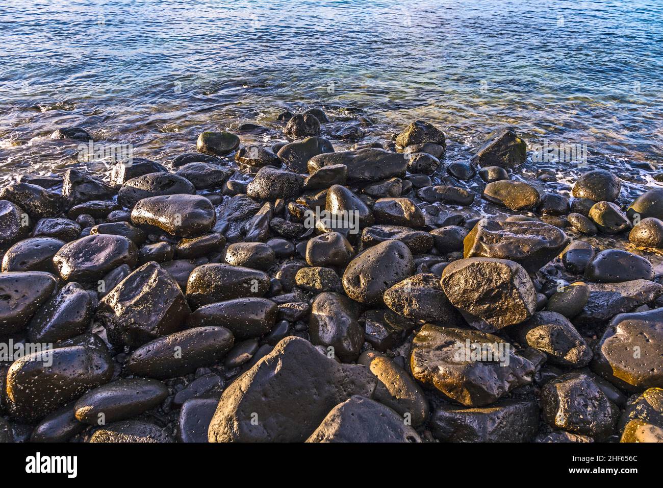 pebble stone beach in morning light with harmonic reflections Stock ...