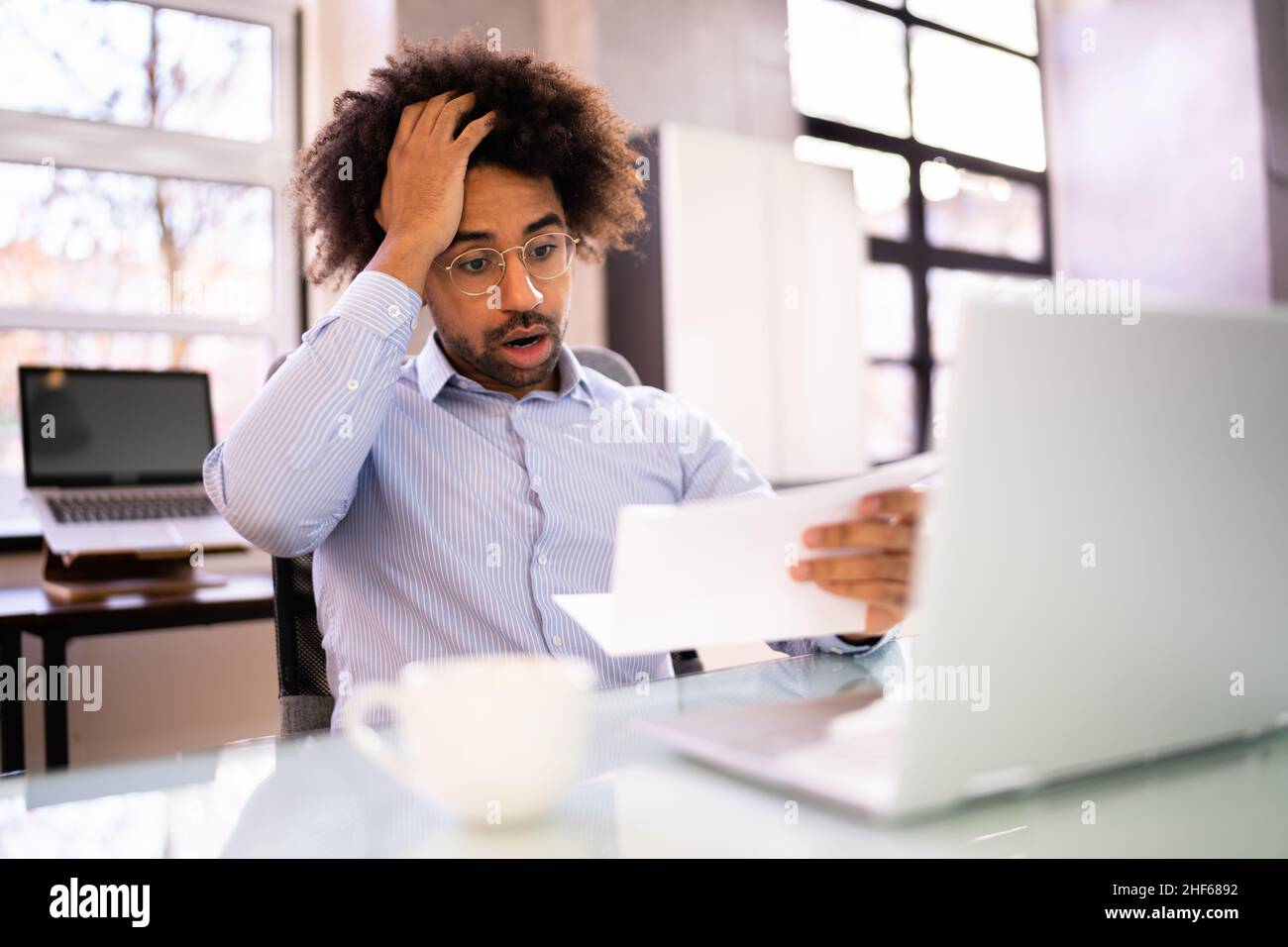 Concerned Man Reading Letter Note At Desk Stock Photo - Alamy