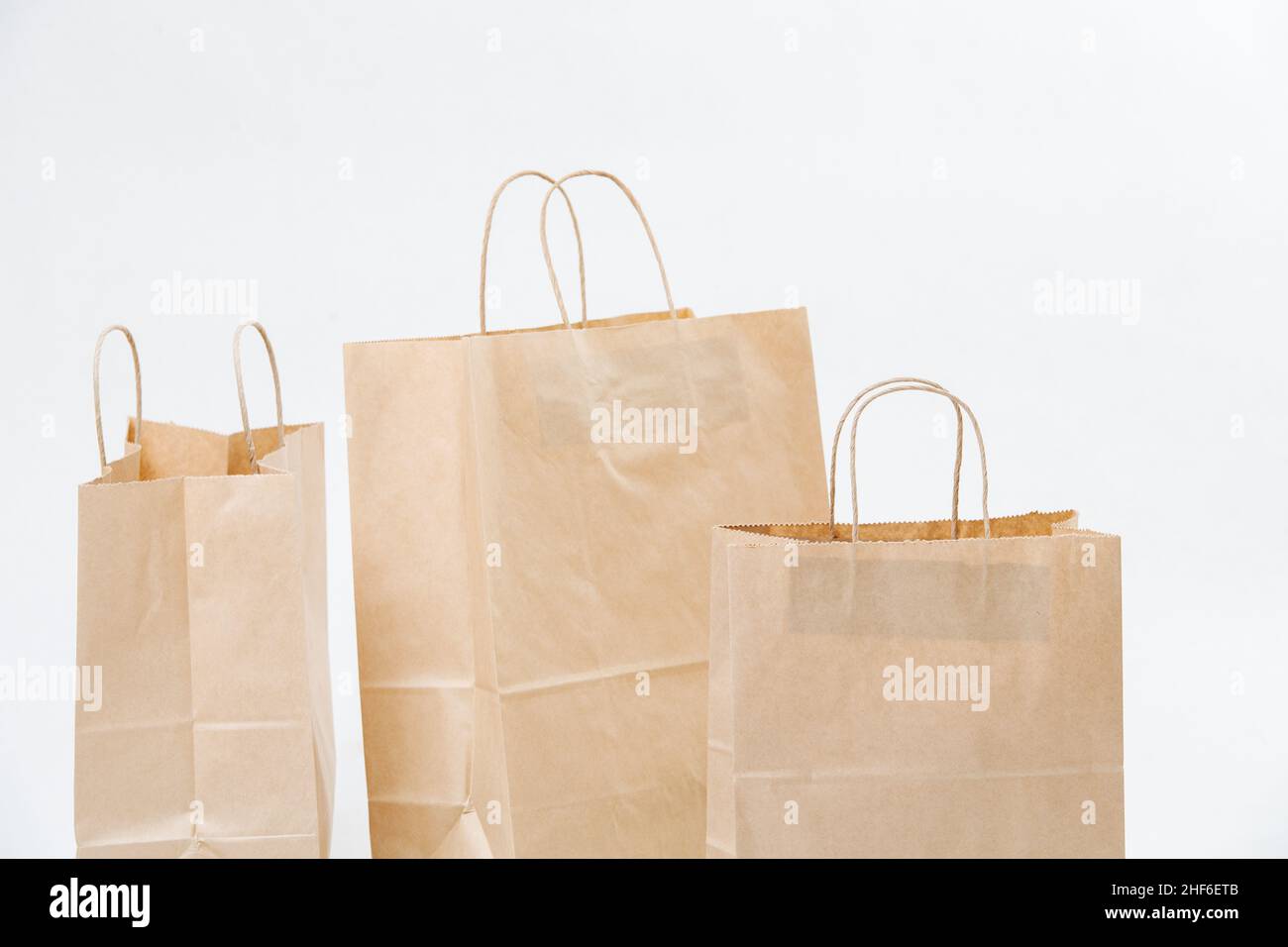 Three empty brown paper bags arranged in a composition over white ...