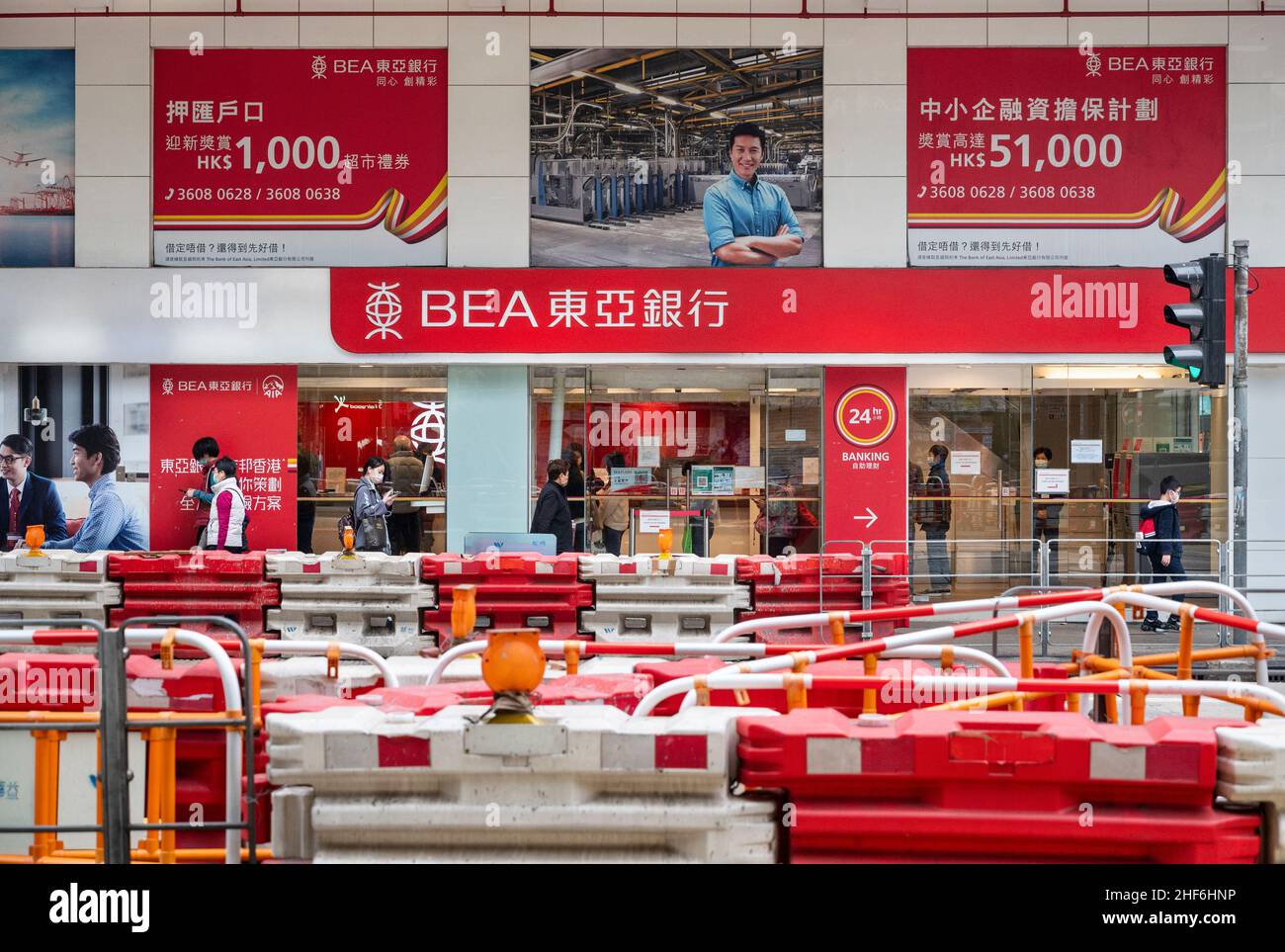 Pedestrians walk past the Bank of East Asia (BEA) branch and logo in Hong Kong. (Photo by Budrul ...