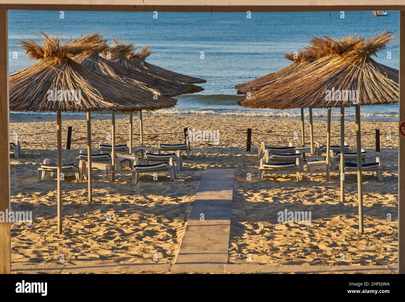 Dawn on the beach. Sun loungers and umbrellas in the rays of the rising ...