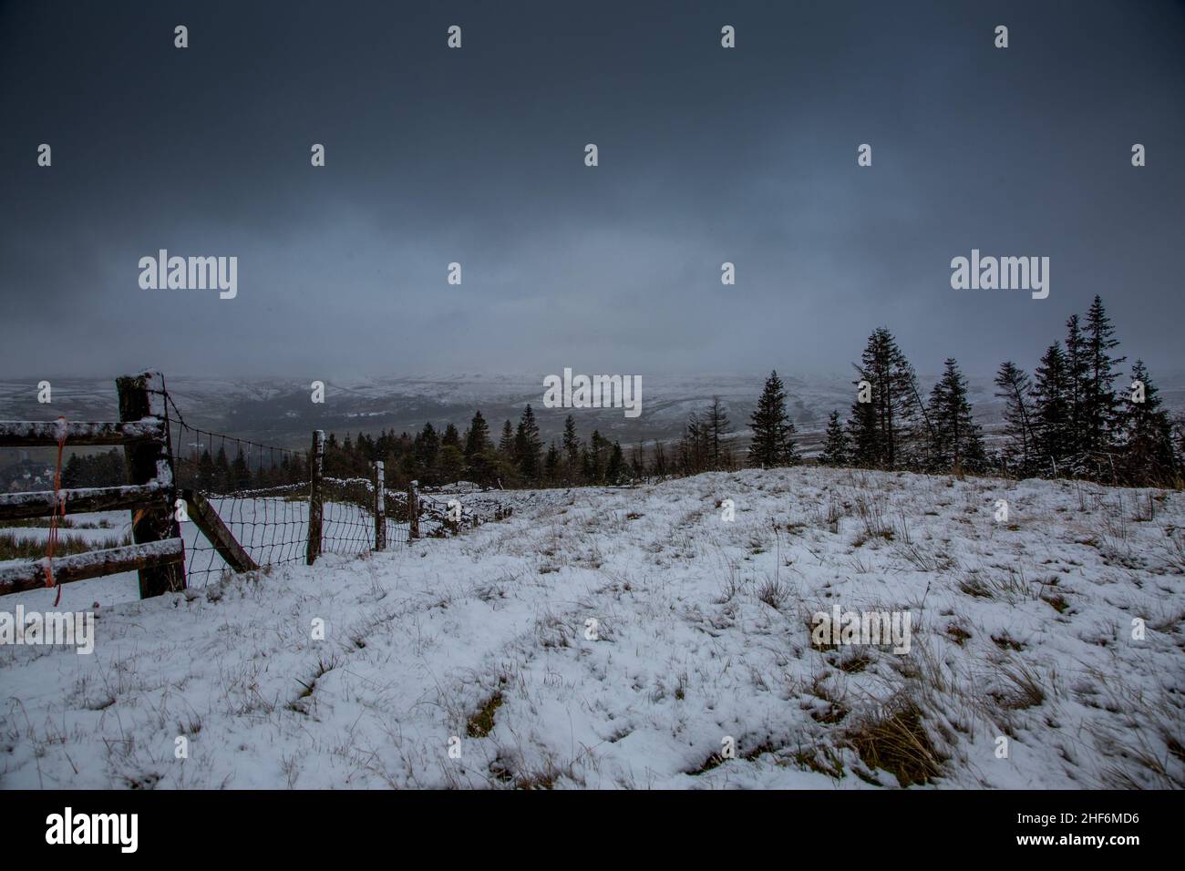 Snow covered fells of Cumbria as ominous looking clouds loom overhead ...