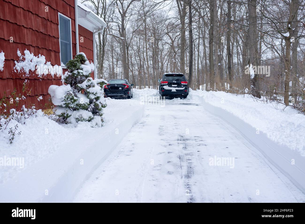 cleaned driveway by red suburban house after the snow storm Stock Photo ...