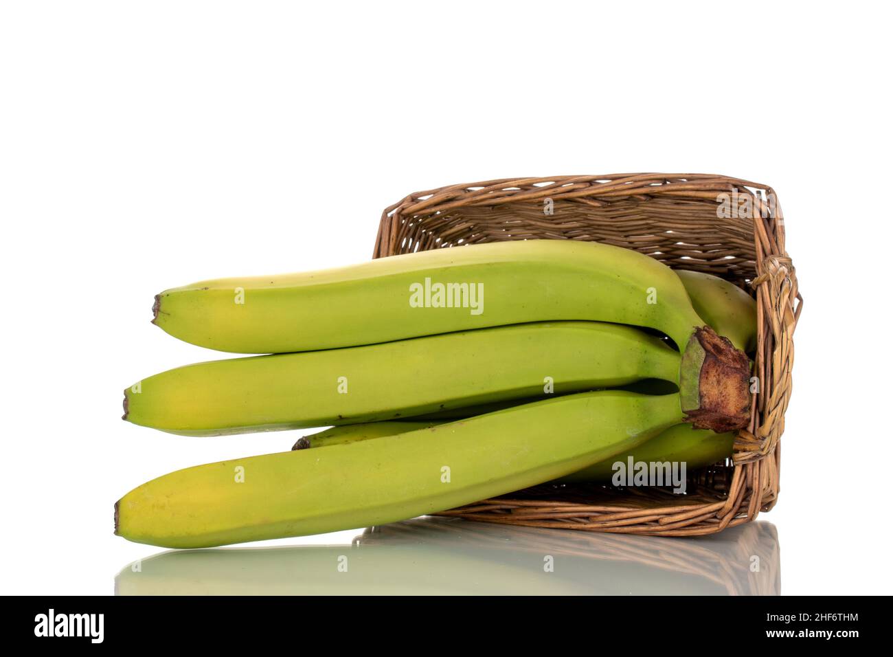 One bunch of organic green bananas in a basket, close-up, isolated on ...