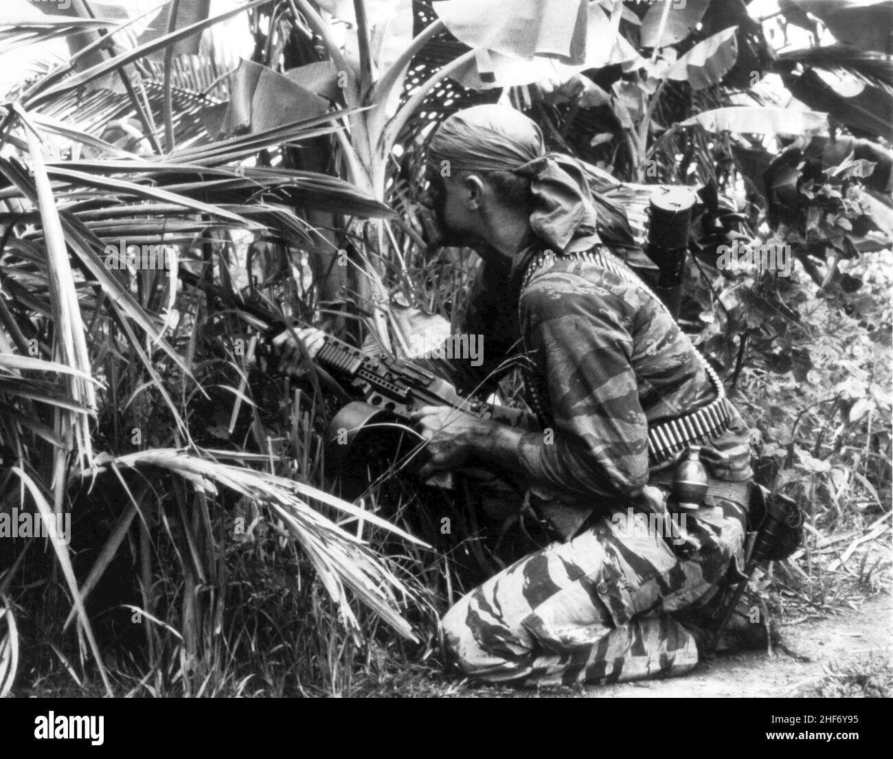 SEAL team member keeps his Mk 23 LMG at the ready while securing stream ...