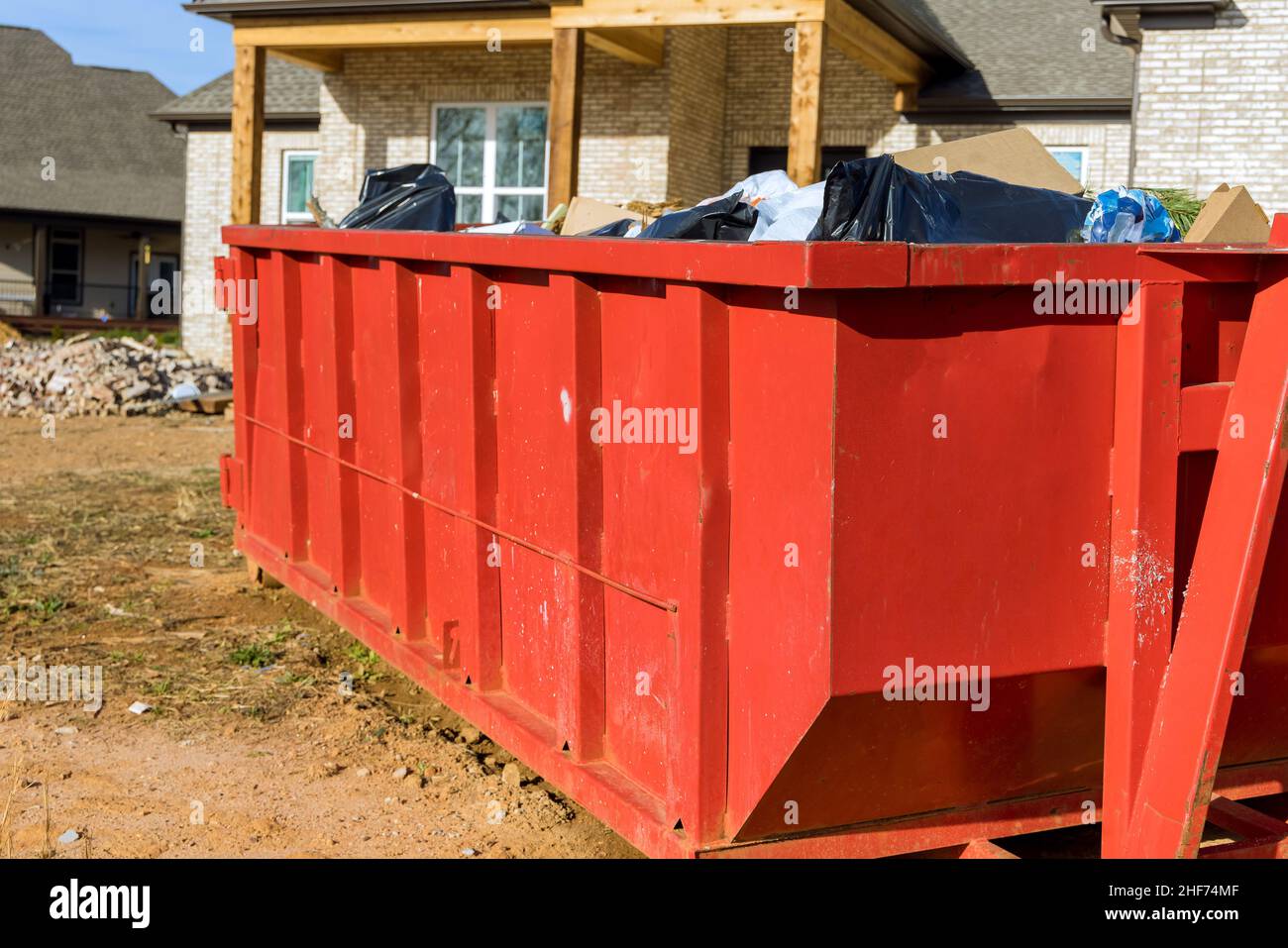 Home renovation maintenance a loaded dumpster near a construction Stock ...