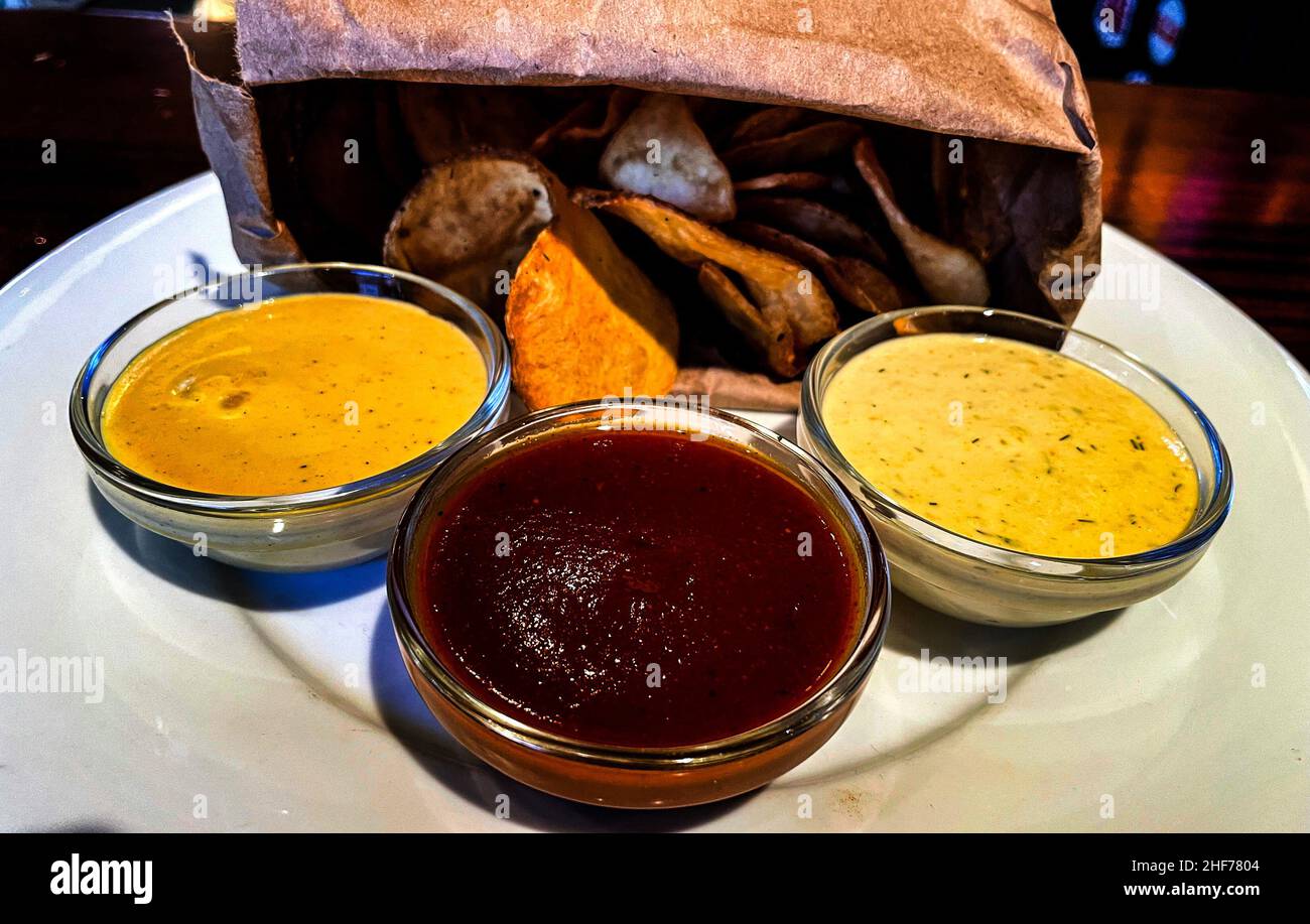 Crisps in a paper bag and three sauces, yummy Stock Photo - Alamy