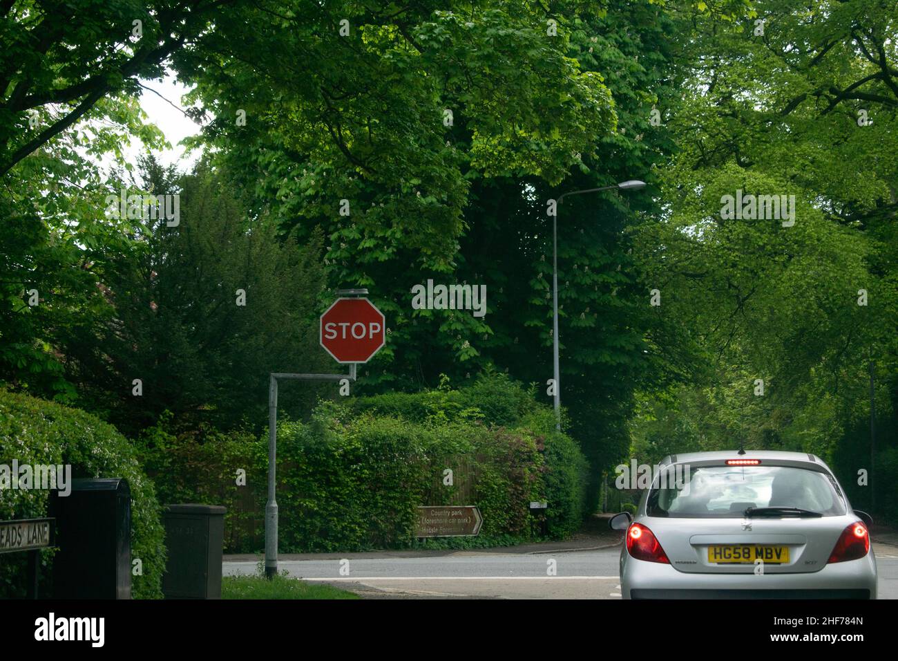 British STOP road sign with stop car waiting for safety before turning ...