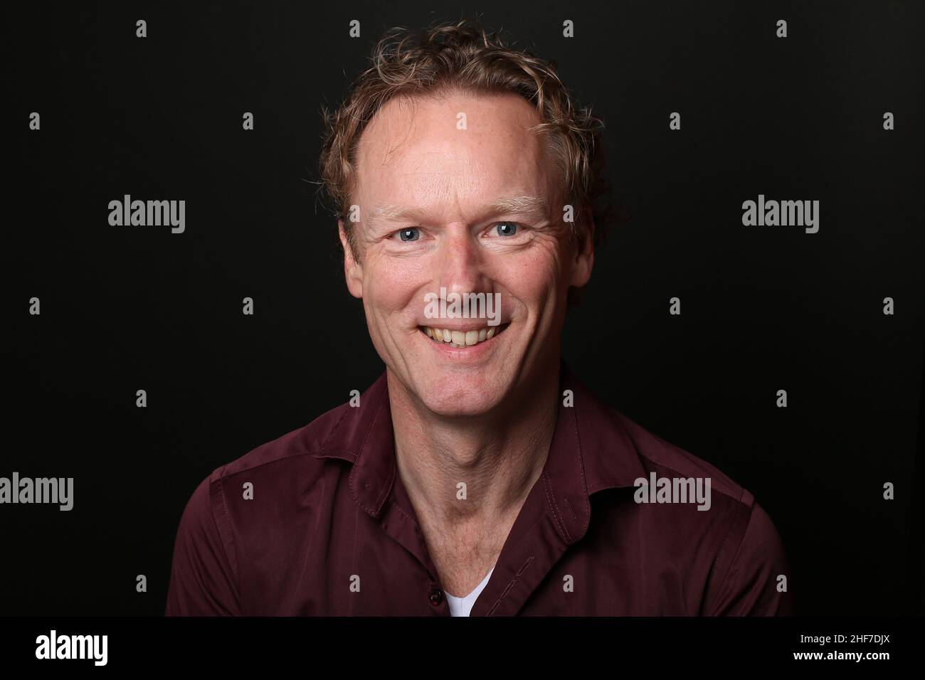 Portrait of a beautiful happy man in front of a colored background ...