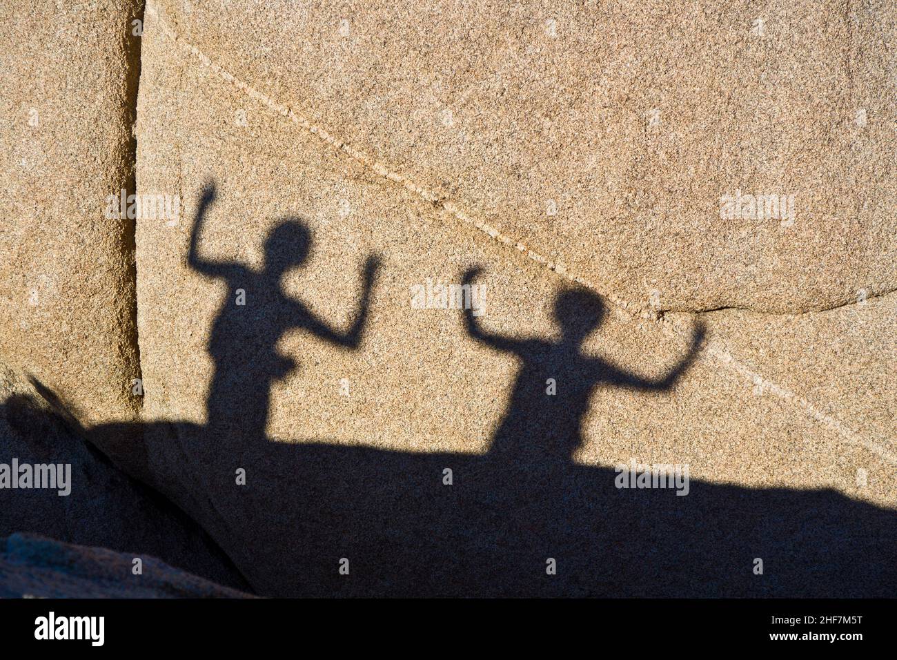children playing with shadows on a rock in Jushua Tree National park ...
