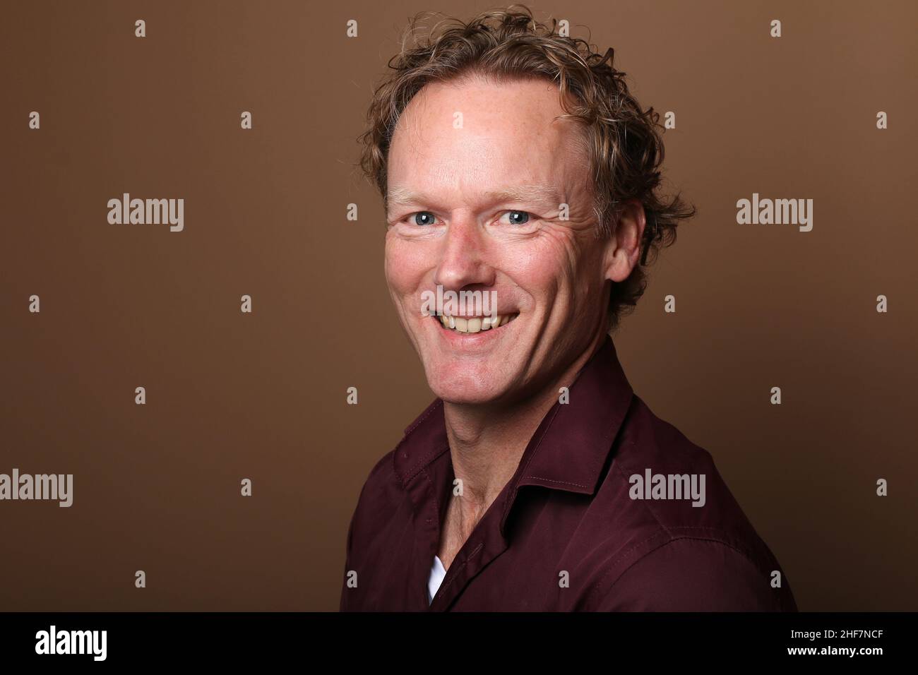 Portrait of a beautiful happy man in front of a colored background ...