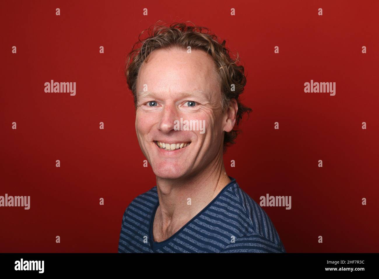 Portrait of a beautiful happy man in front of a colored background ...
