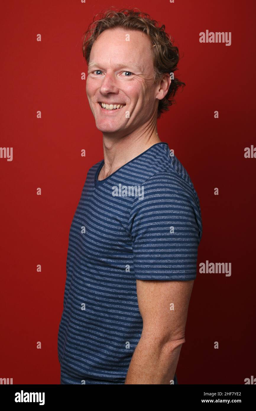 Portrait of a beautiful happy man in front of a colored background ...