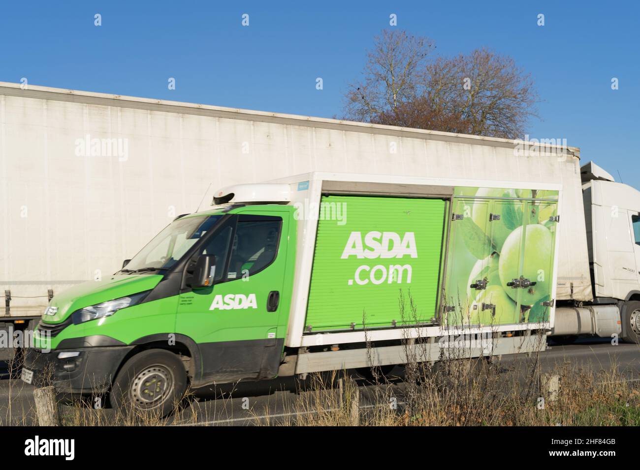 ASDA delivery van drives past a white HGV lorry in London Greenwich ...
