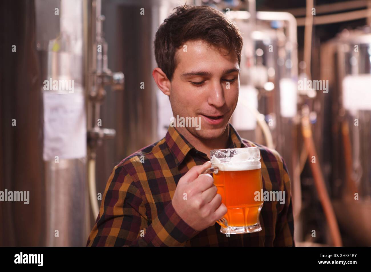 Excited brewer tasting freshly brewed beer at his microbrewery Stock ...