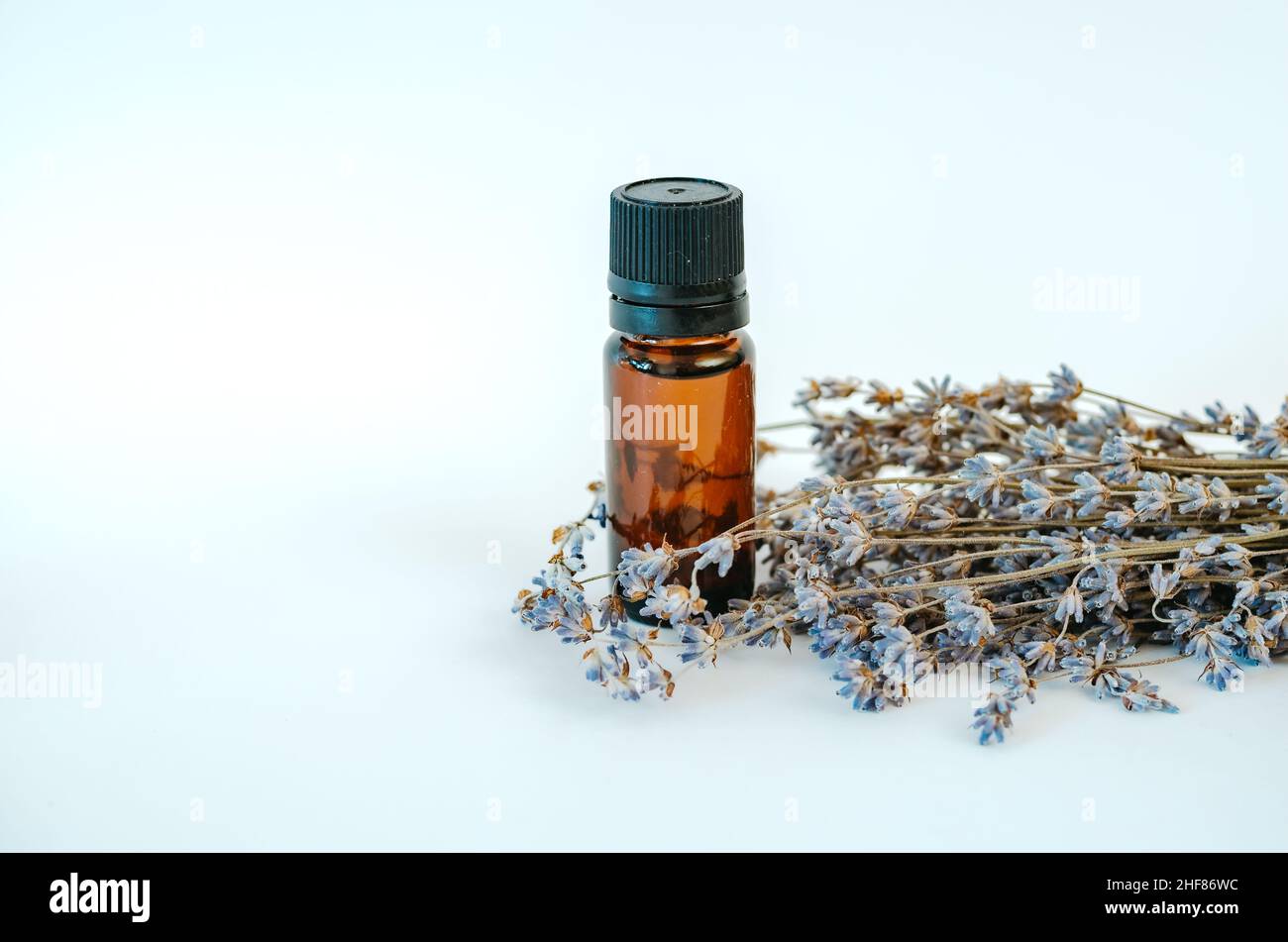 Bottle of essential oil/perfume in dried lavender without label on ...