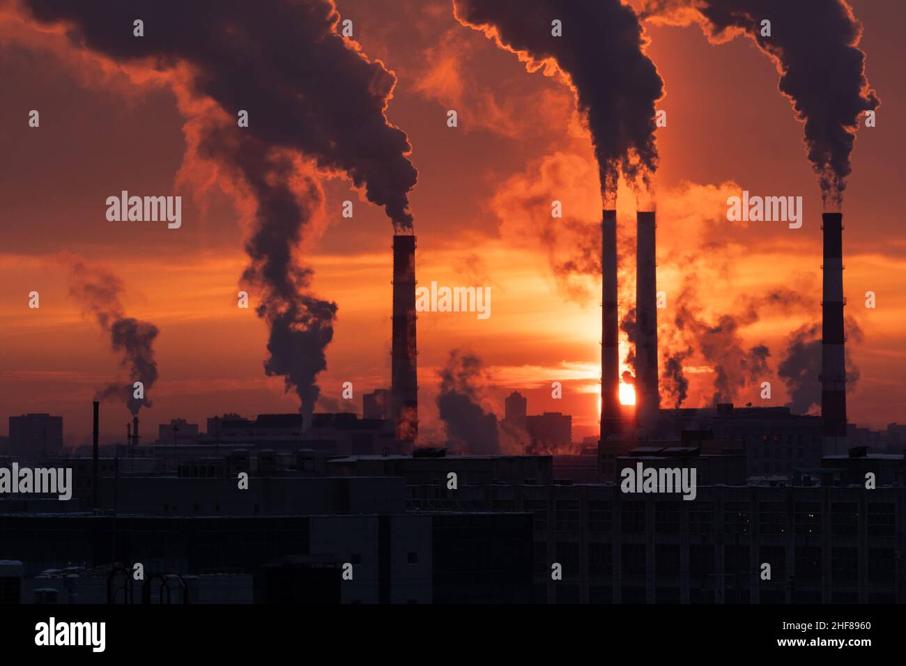 Smoke from heating station in winter season, view at sunset. Air ...