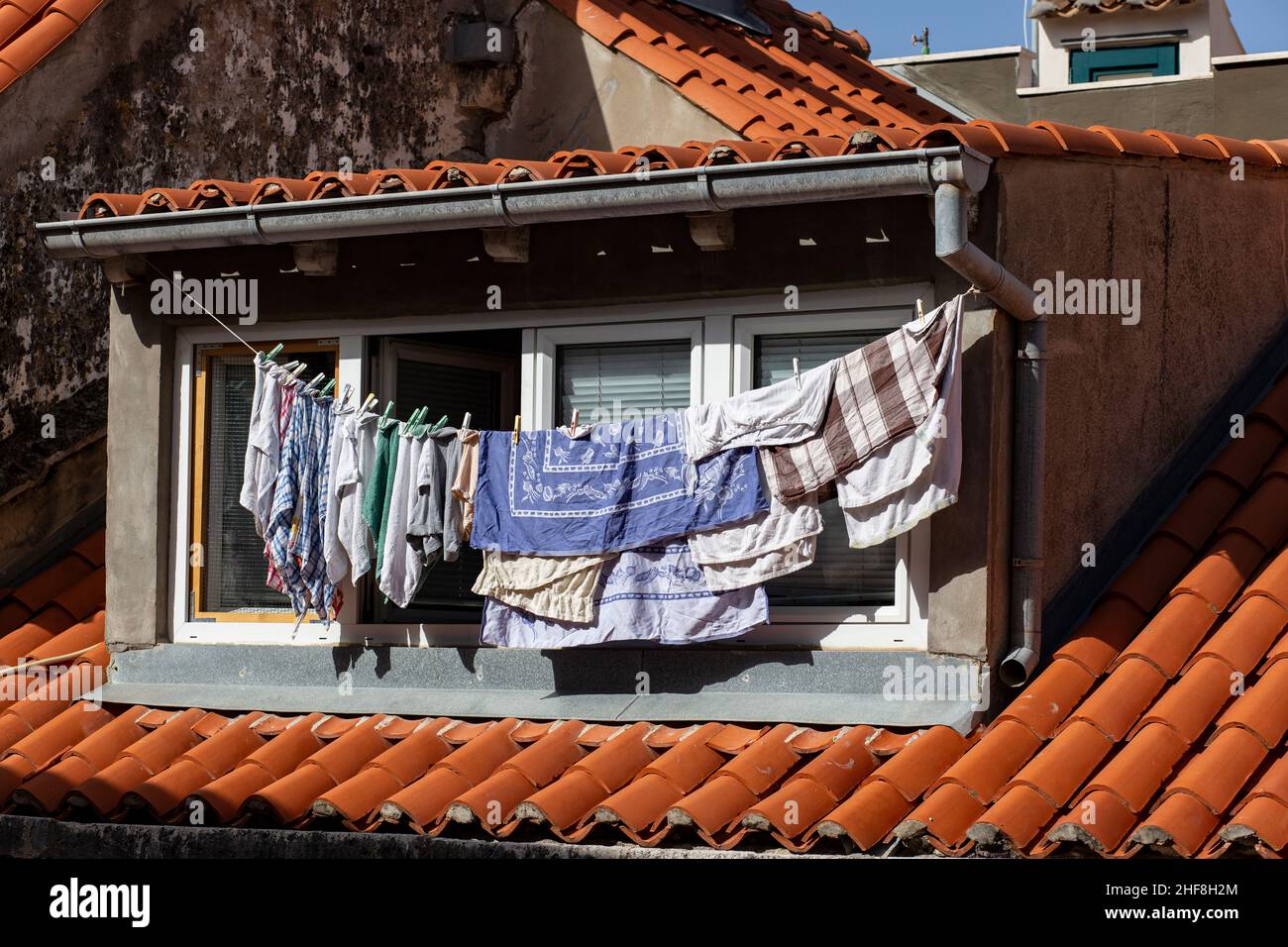 washing drying from a washing line out side a rooftop window in ...