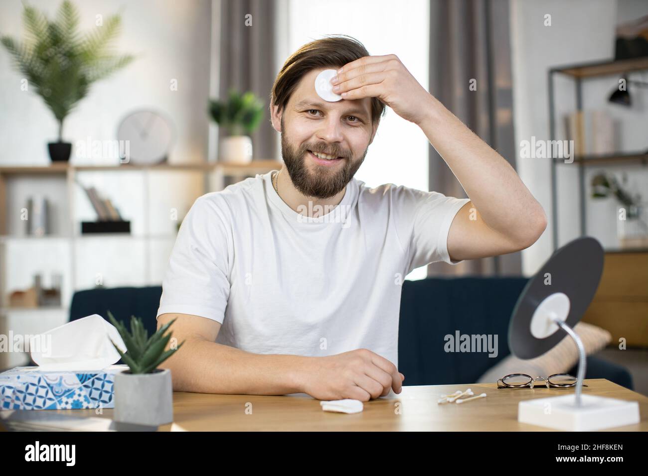 Attractive smiling Caucasian guy performs hygienic procedures, cleaning ...