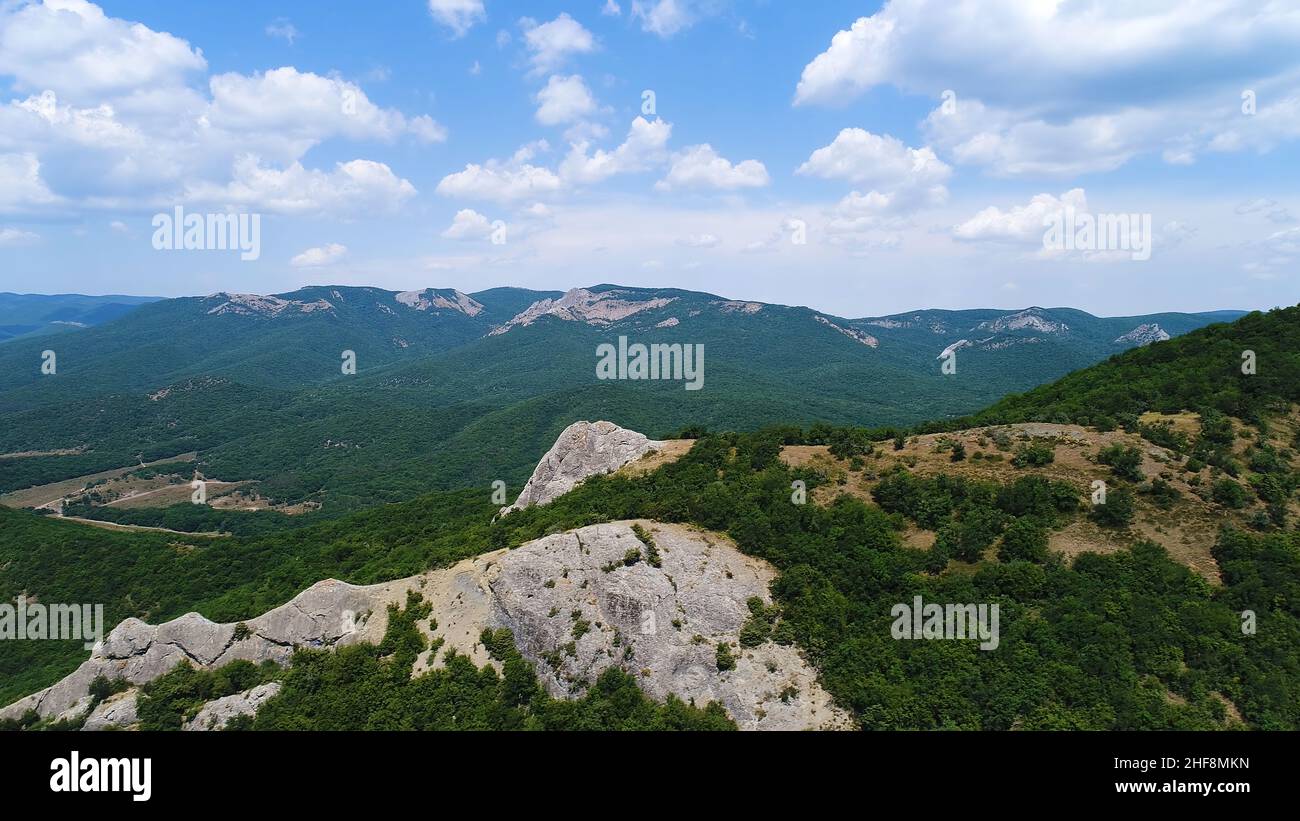 Aerial view of mountain rocks with a vast valley on blue cloudy sky ...