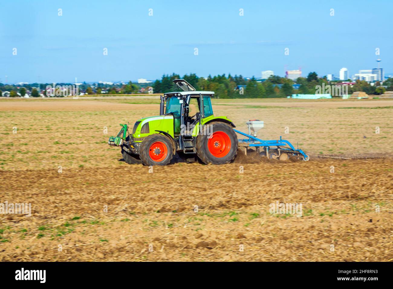 Small scale farming with tractor and plow in field Stock Photo - Alamy