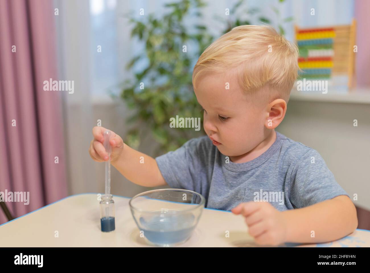 little boy child blonde play chemical experiments to sit at the table ...
