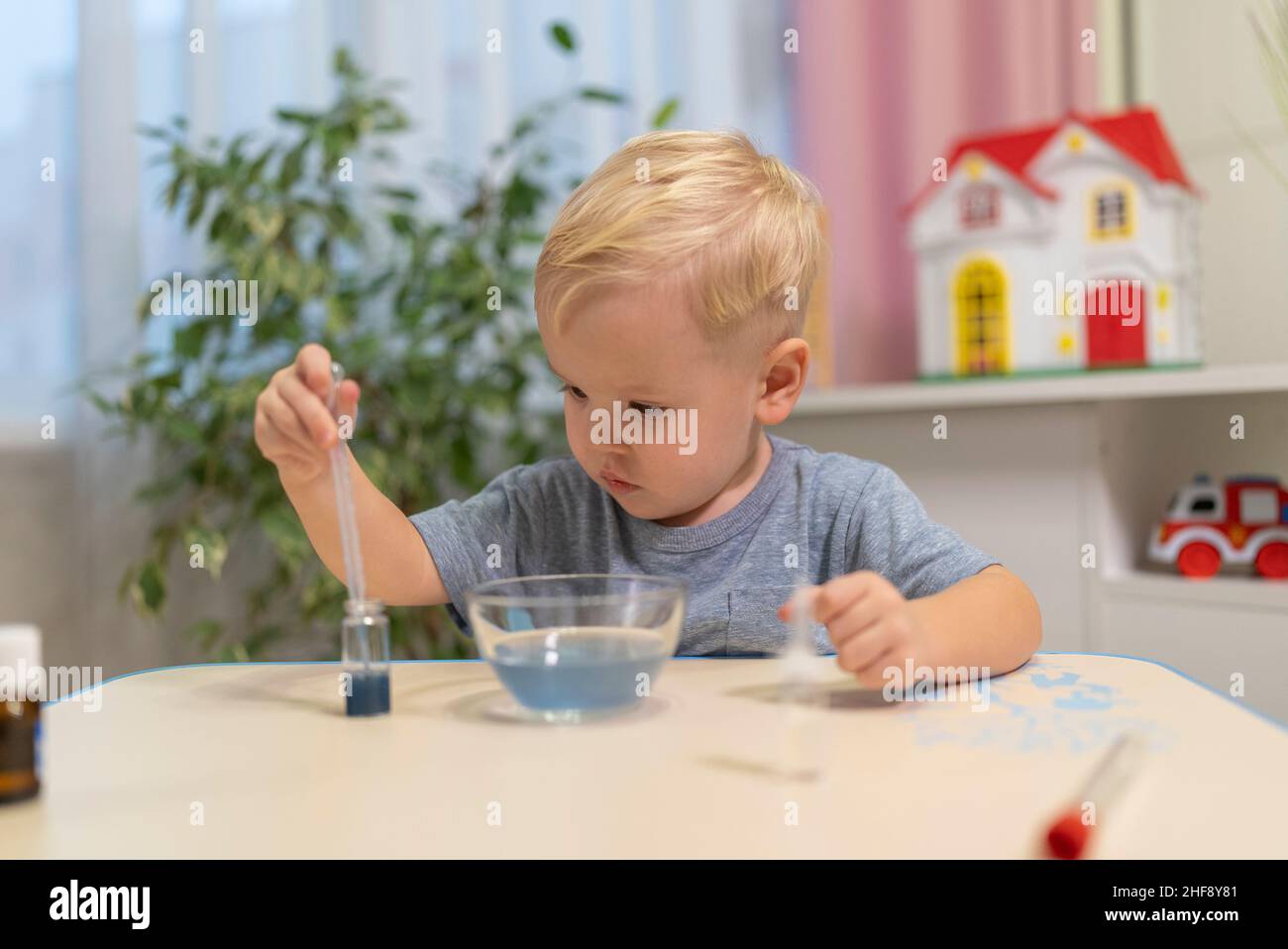 little boy child blonde play chemical experiments to sit at the table ...