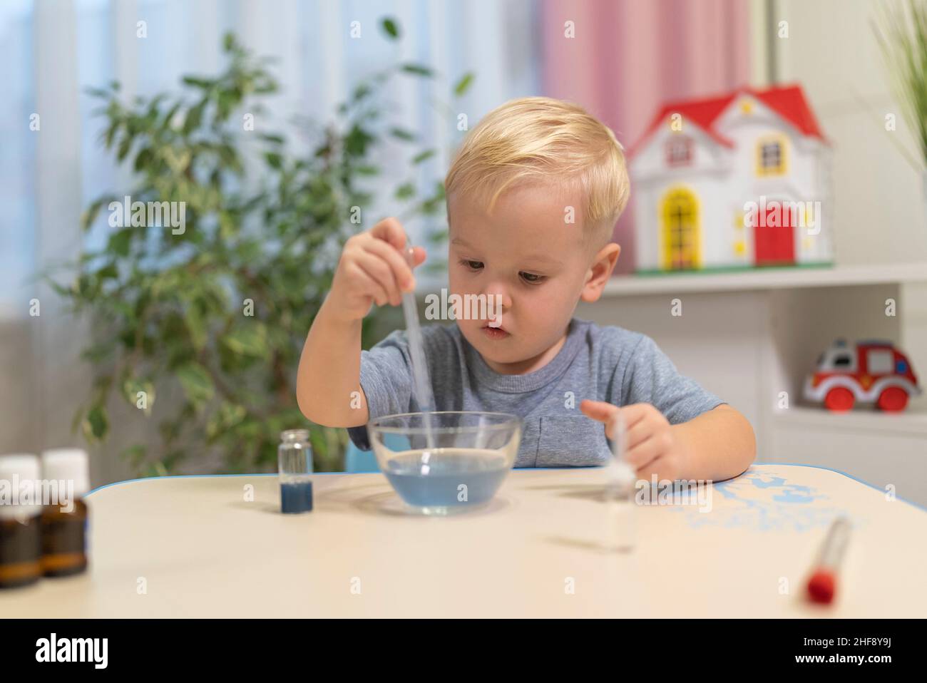 little boy child blonde play chemical experiments to sit at the table ...