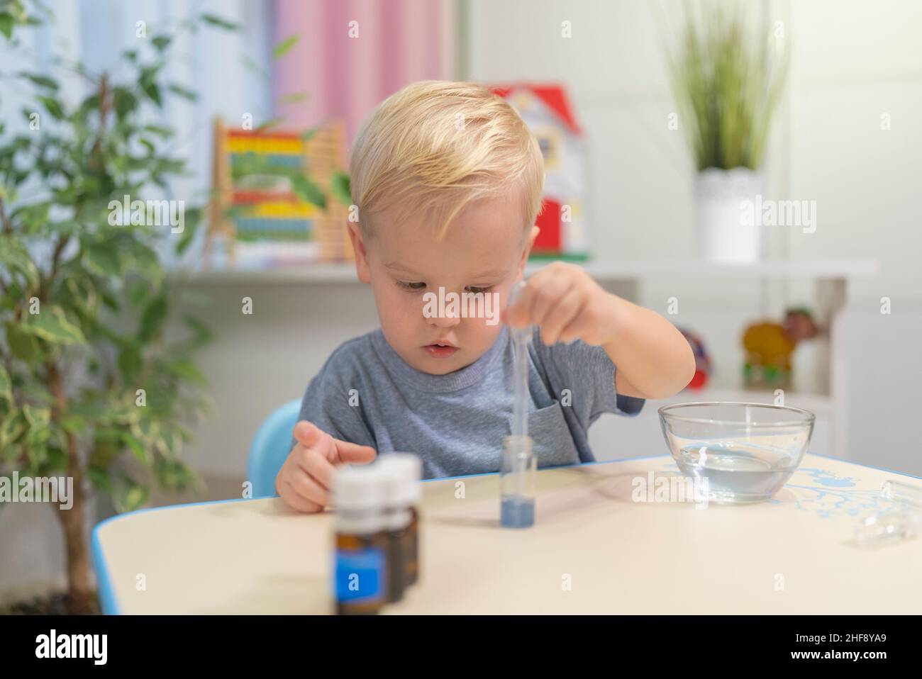 little boy child blonde play chemical experiments to sit at the table ...