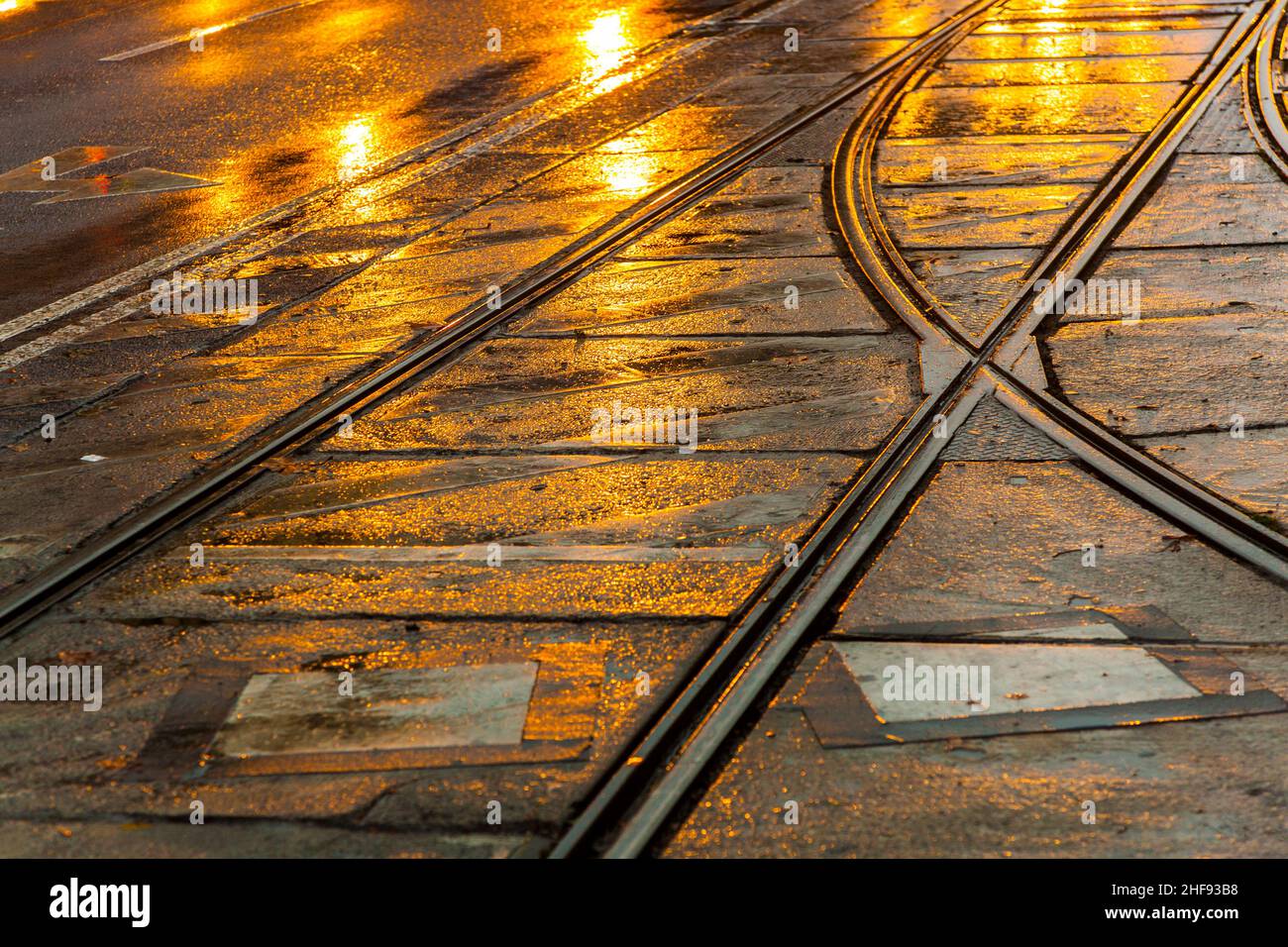 wet trolley rails in the light and streets are reflecting light Stock ...
