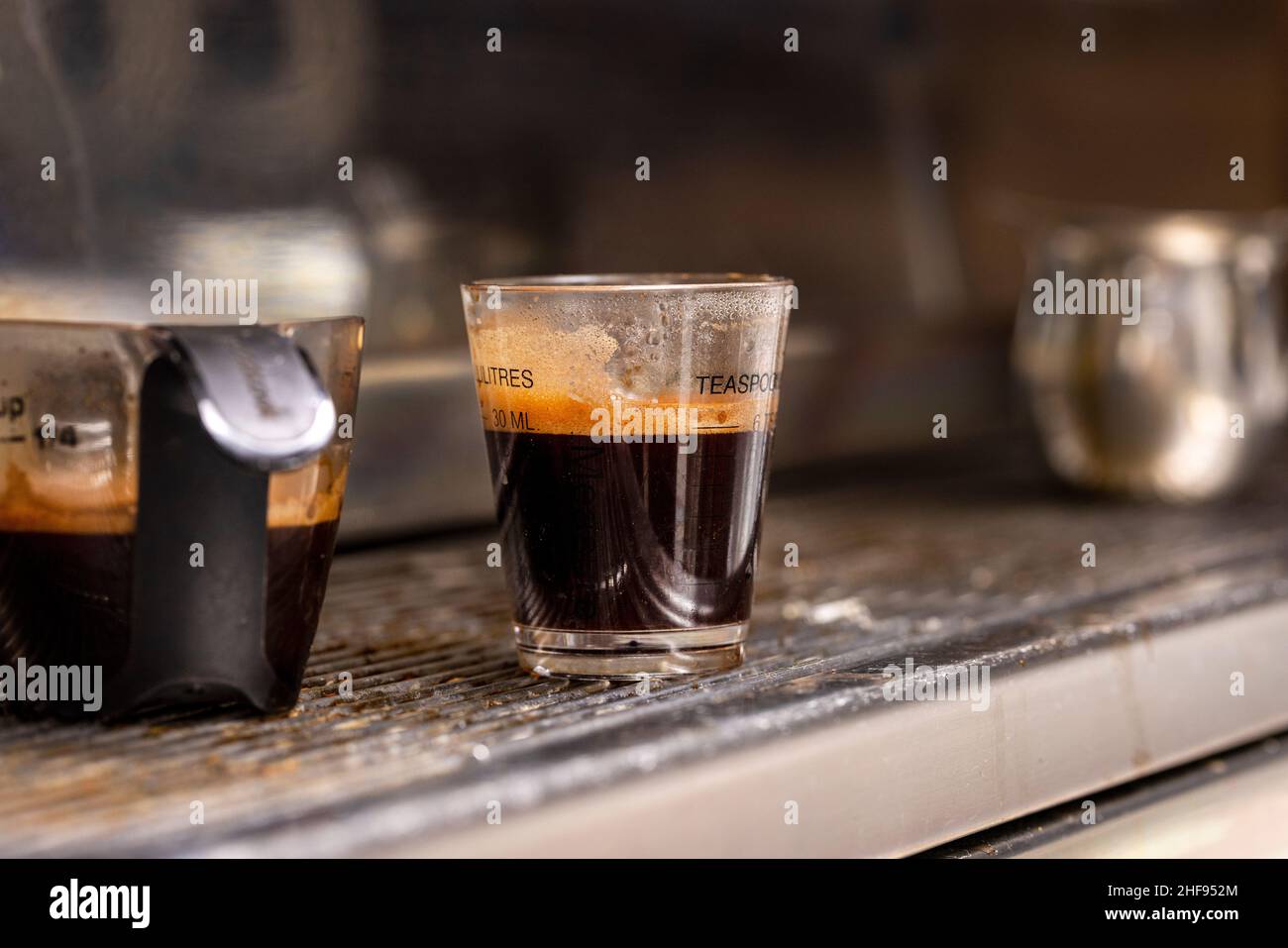 Coffee shots being poured at an expresso machine at a coffee house ...