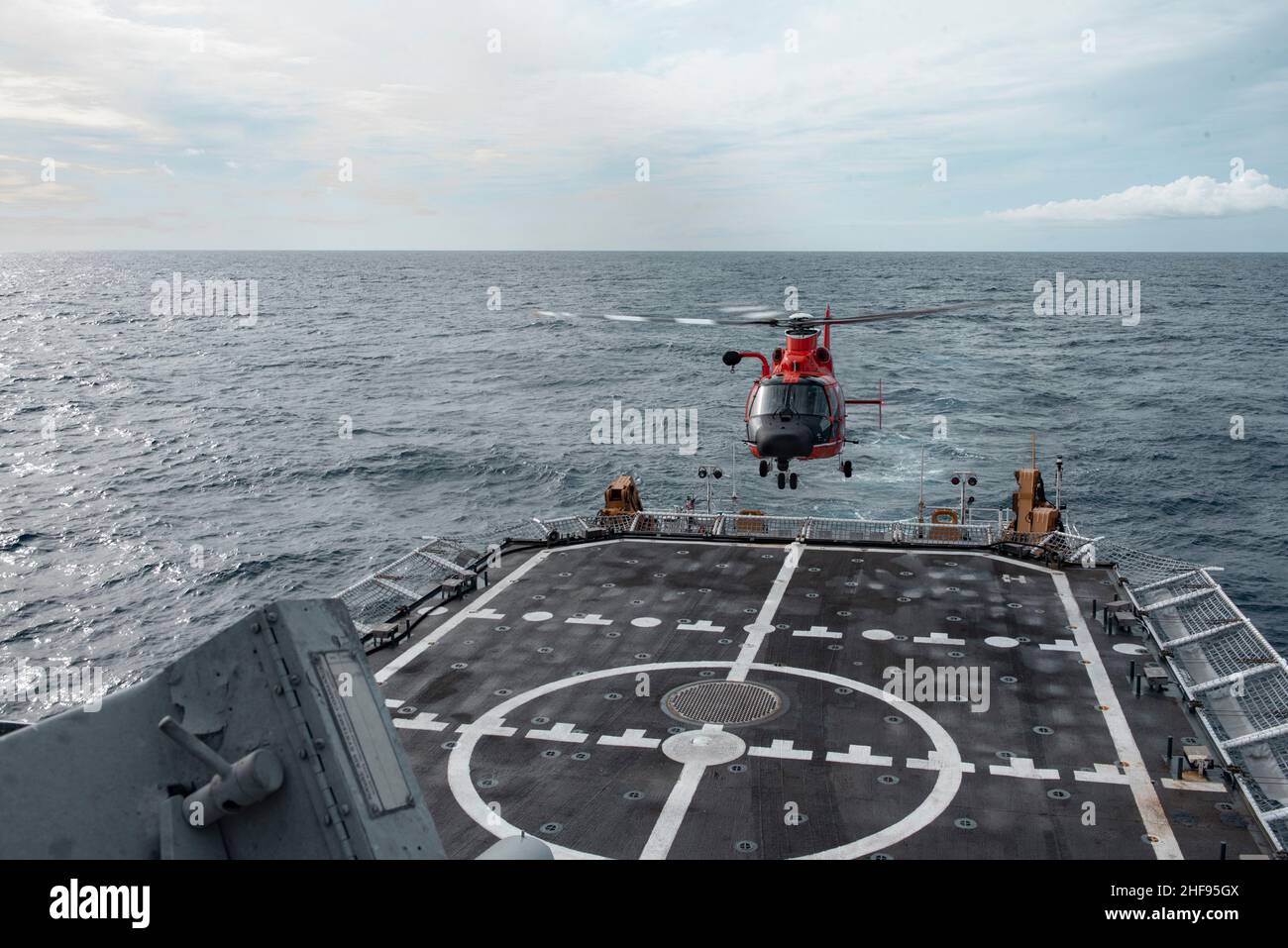 A U.S. Coast Guard MH-65E Dolphin helicopter prepares to land on the ...